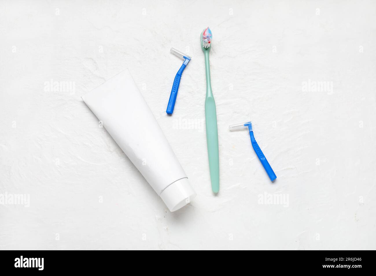 Toothbrush, toothpicks and paste on textured white background Stock ...