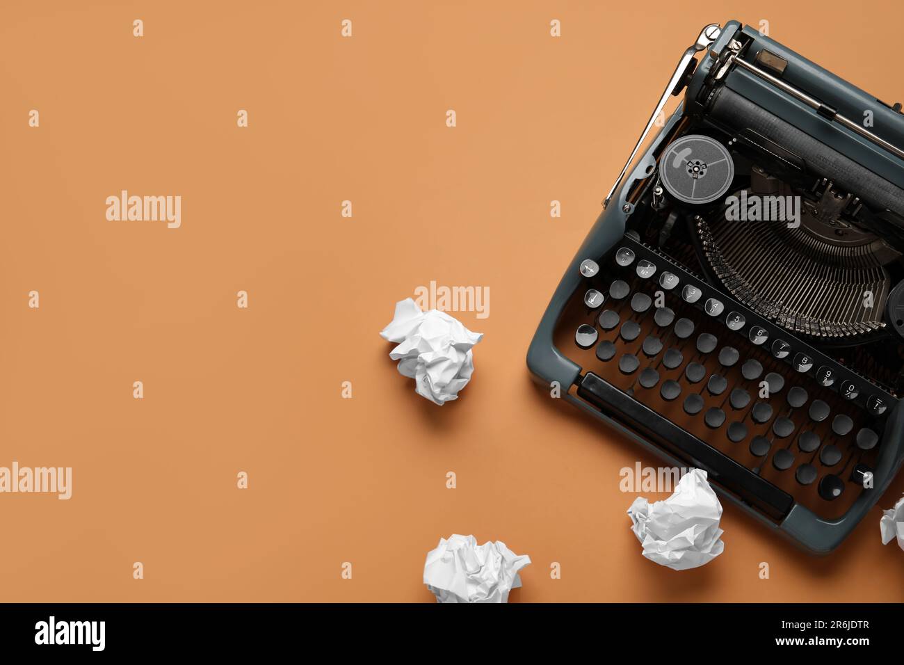 Vintage typewriter with crumpled paper on orange background Stock Photo ...