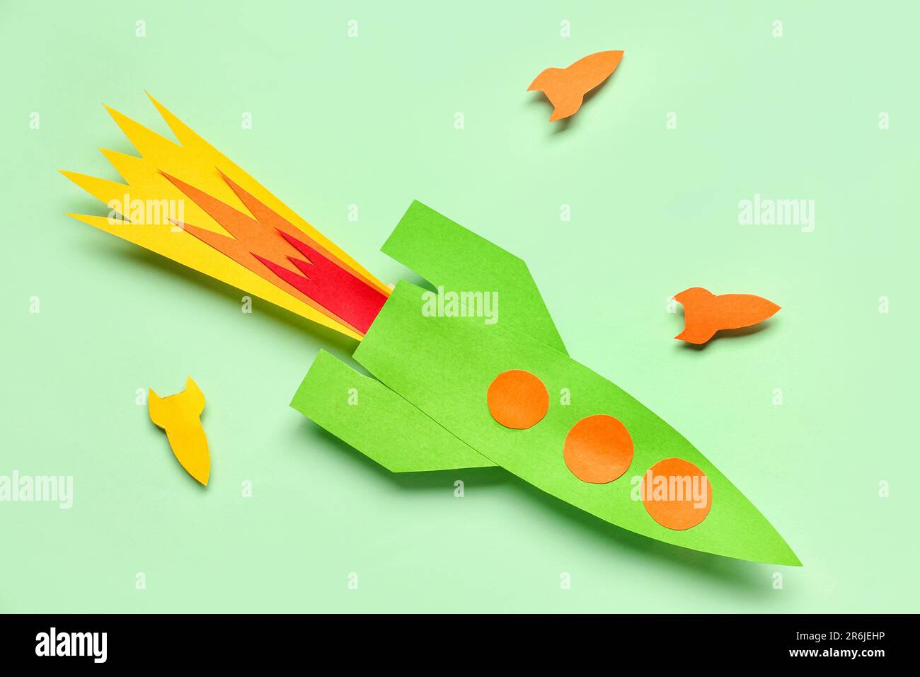 Colorful paper rockets on pale green background Stock Photo - Alamy
