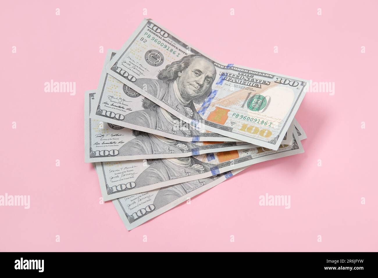 One hundred dollar banknotes on pink background Stock Photo - Alamy
