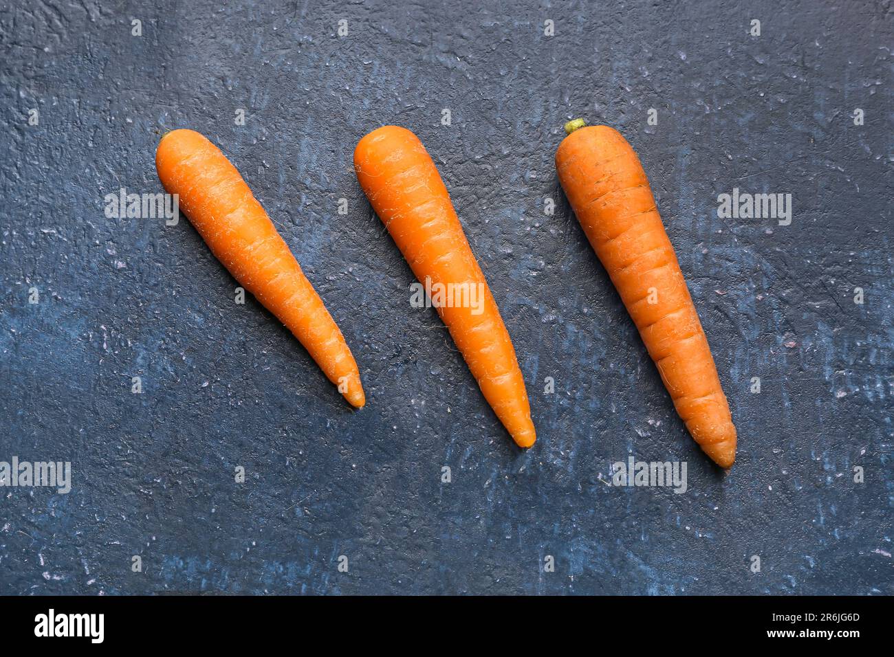 Fresh carrots on blue background Stock Photo - Alamy