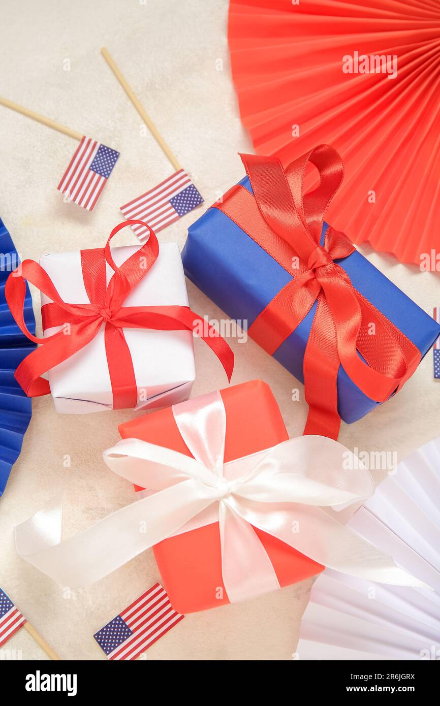 Gift boxes with USA flags and colorful fans on white background ...
