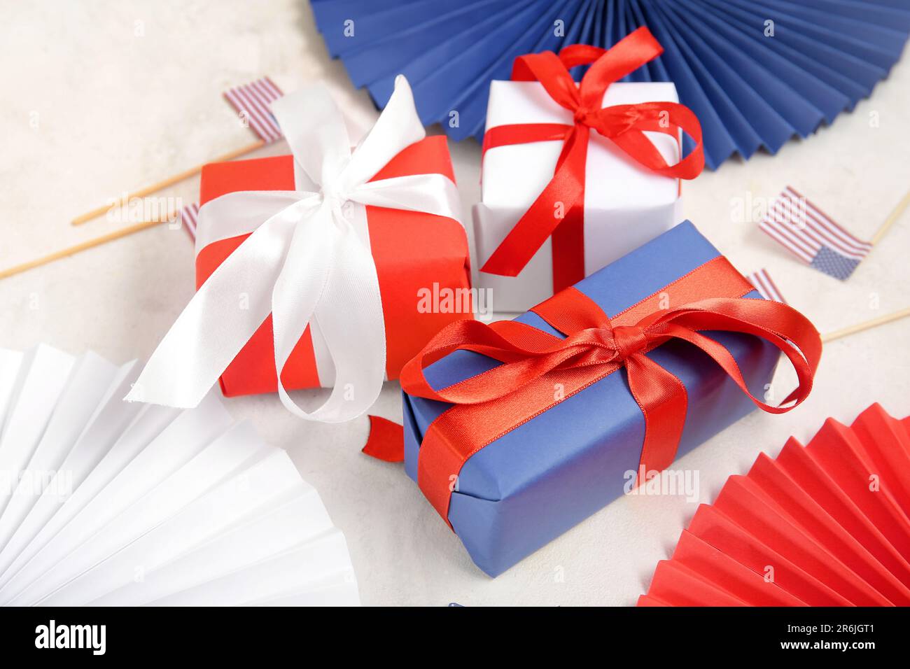 Gift boxes with USA flags and colorful fans on white background ...