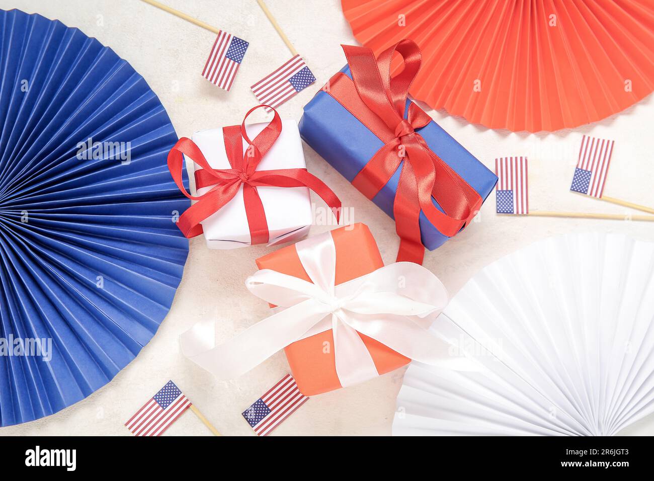 Gift boxes with USA flags and colorful fans on white background ...