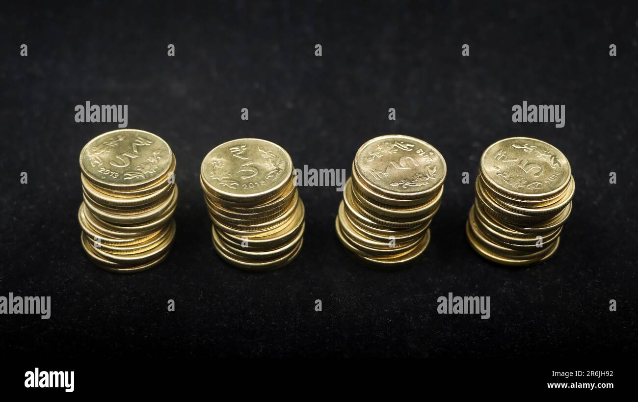 stacks of vintage indian gold 5 or five rupee coins divided equally and ...