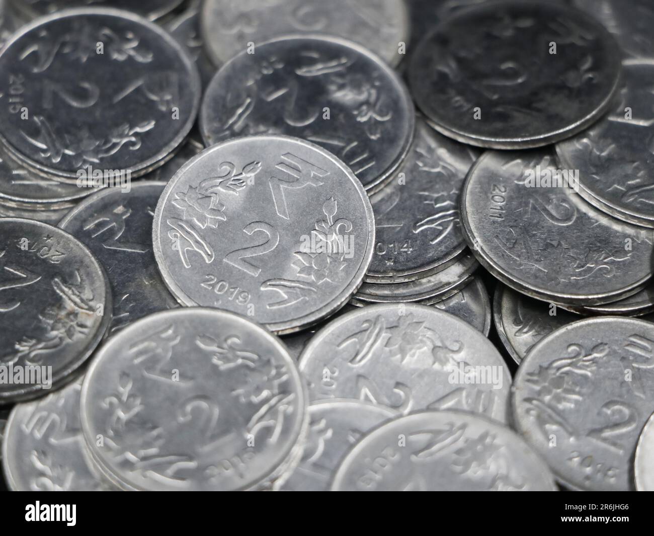 closeup of a collection of indian 2 ( two ) rupee coins made of silver ...
