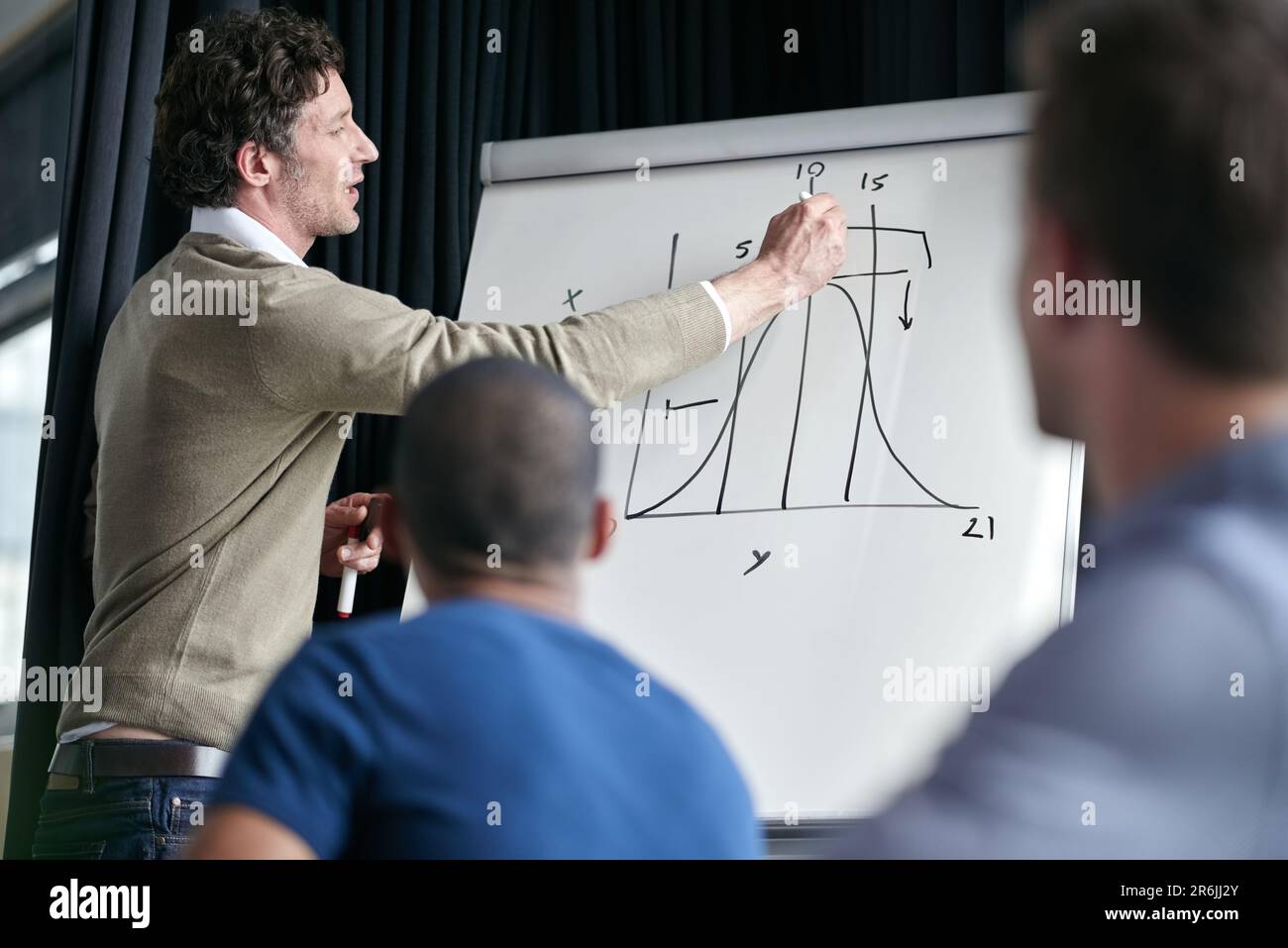 Man, presentation and writing on chart, board and group of business ...