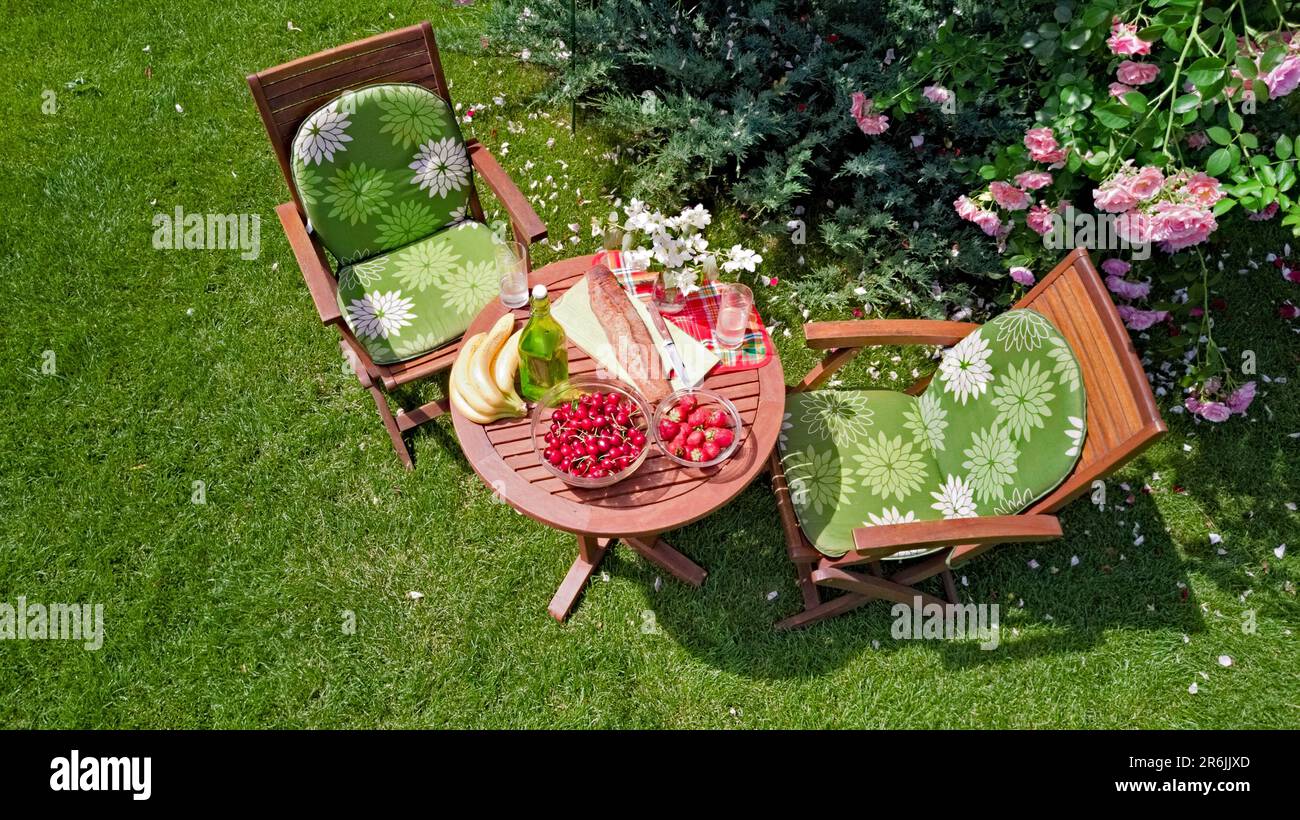 Decorated table with bread, strawberry and fruits in beautiful summer ...