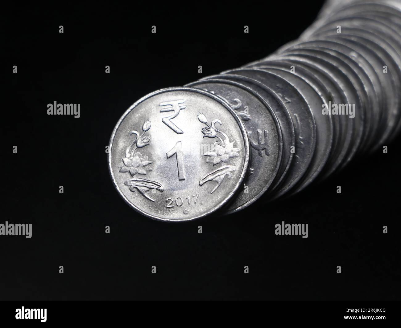 1 (one) rupee coins of india made of silver stacked together in a ...