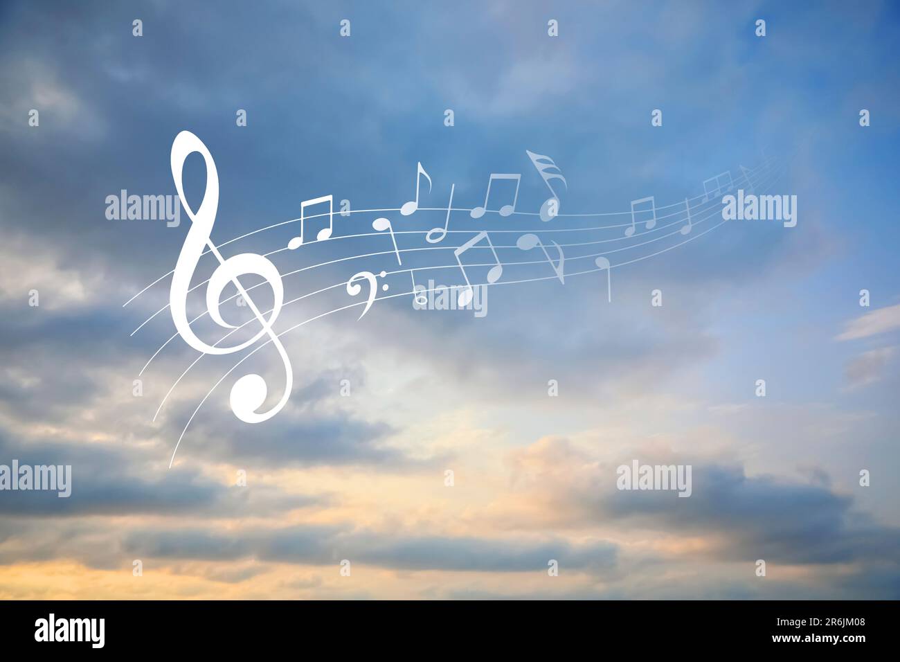 Staff with treble clef and musical notes against sunset sky Stock Photo ...
