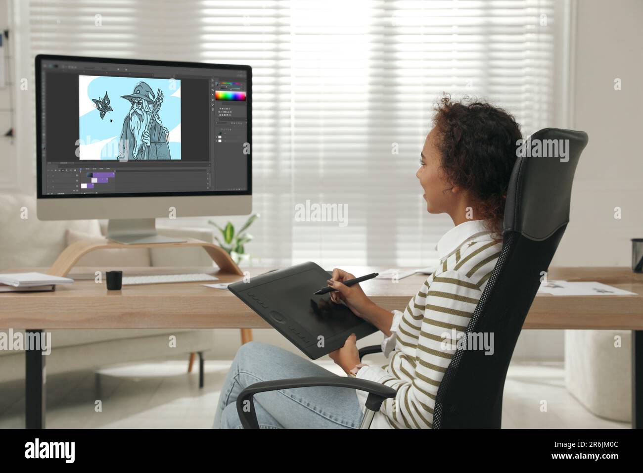 African American animator using graphic tablet and computer ...