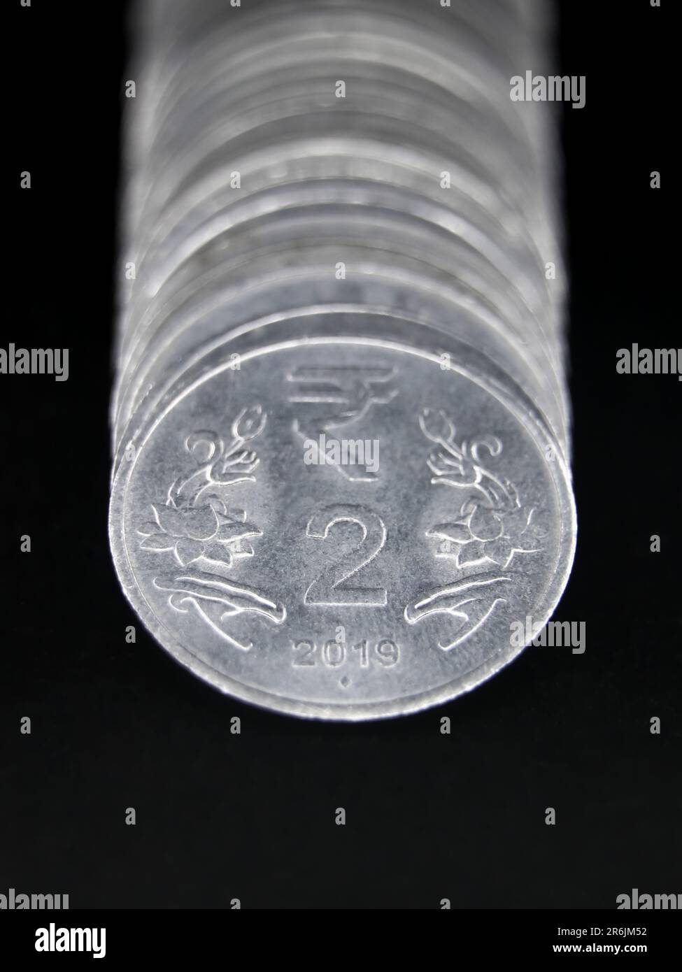 shiny 2 or two rupee silver coins of india arranged in a straight ...