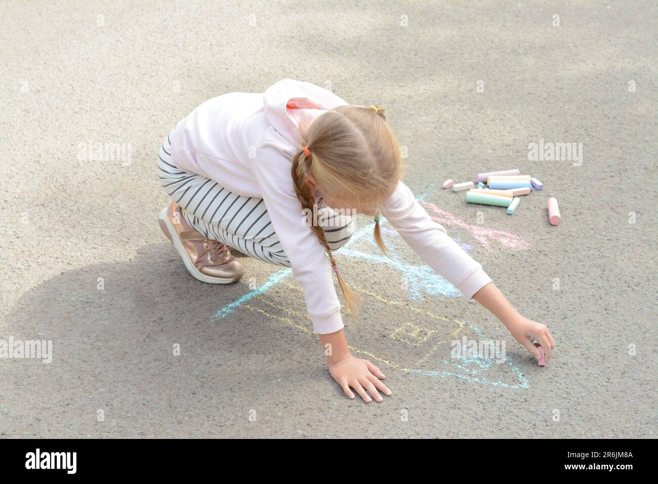 Little child drawing happy family with chalk on asphalt Stock Photo - Alamy