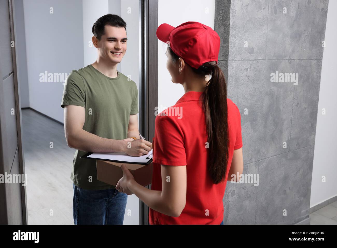 Customer signing delivery from courier hi-res stock photography and ...