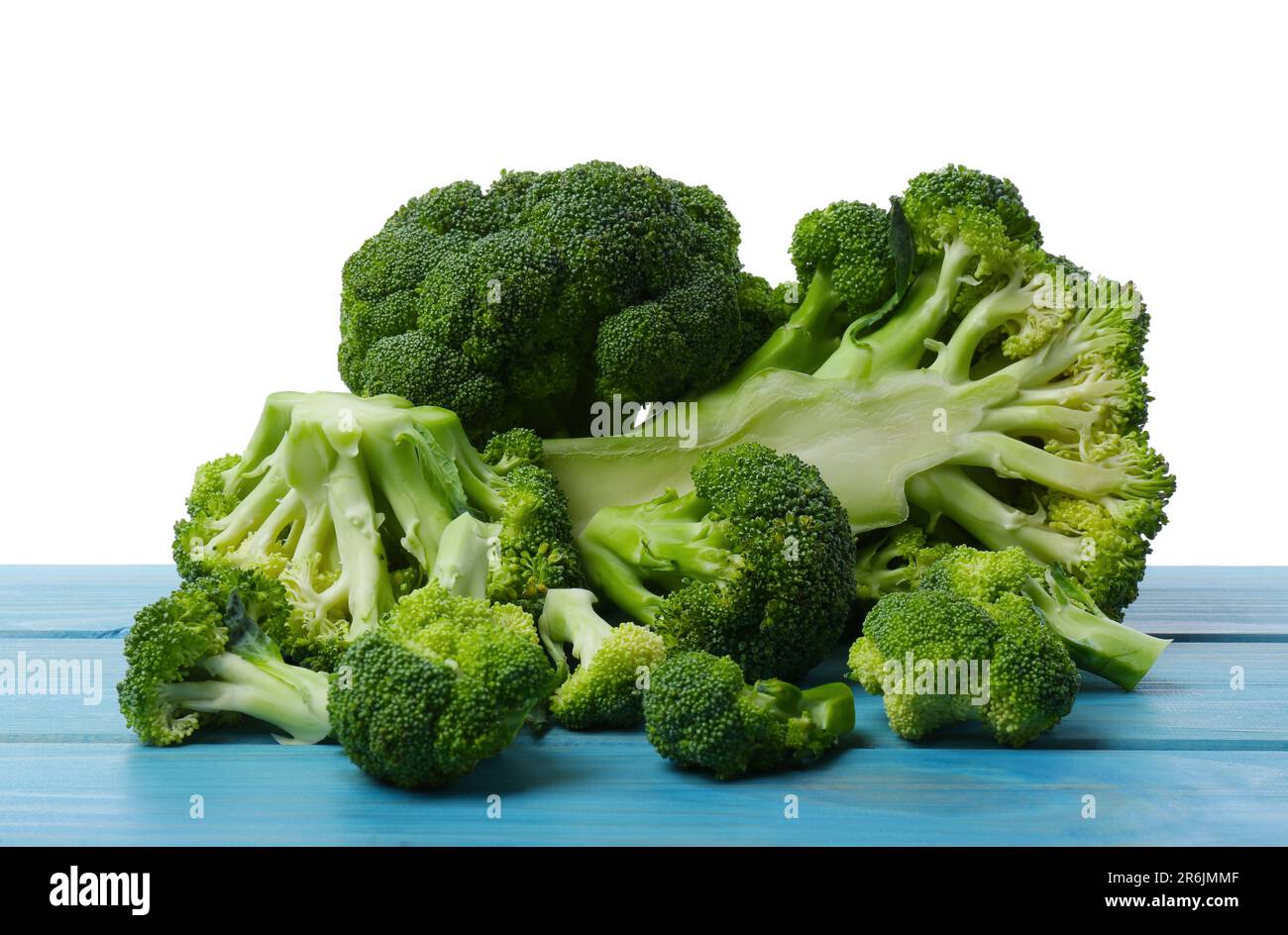 Fresh broccoli on light blue wooden table against white background ...