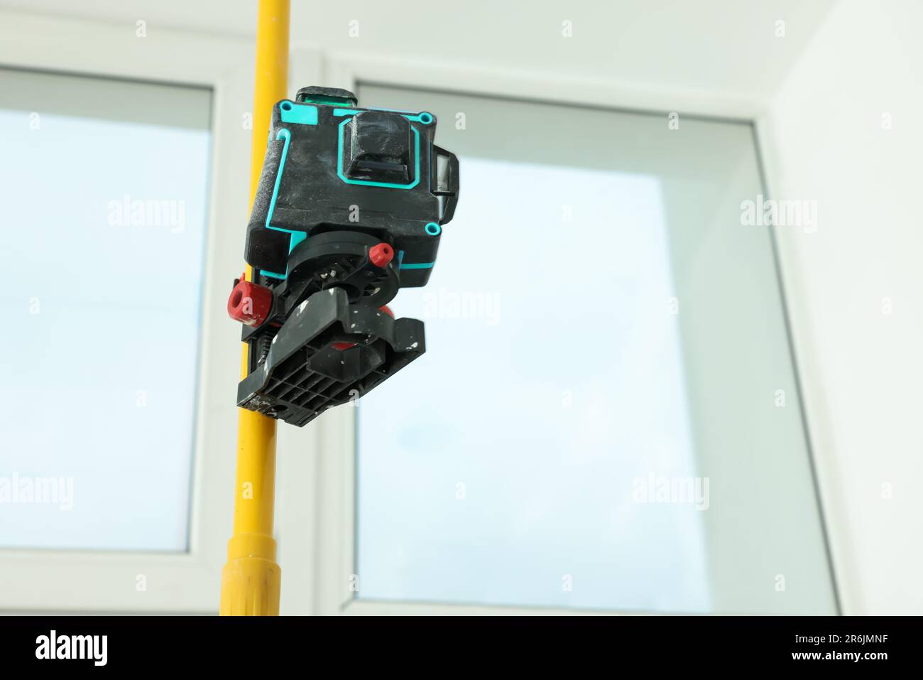 Modern cross line laser level near window, space for text. Tiles ...