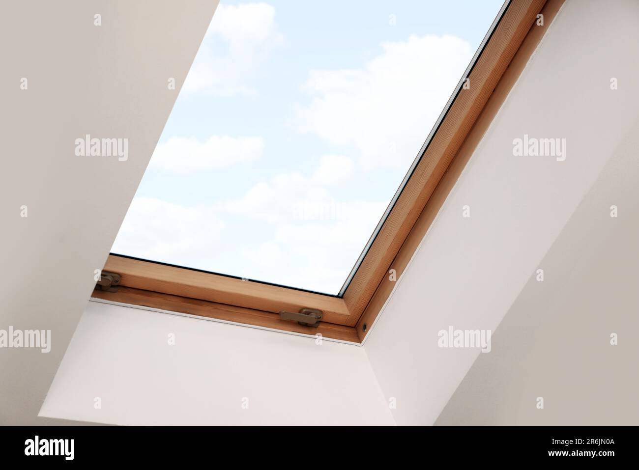 Skylight roof window on slanted ceiling in attic room, low angle view ...
