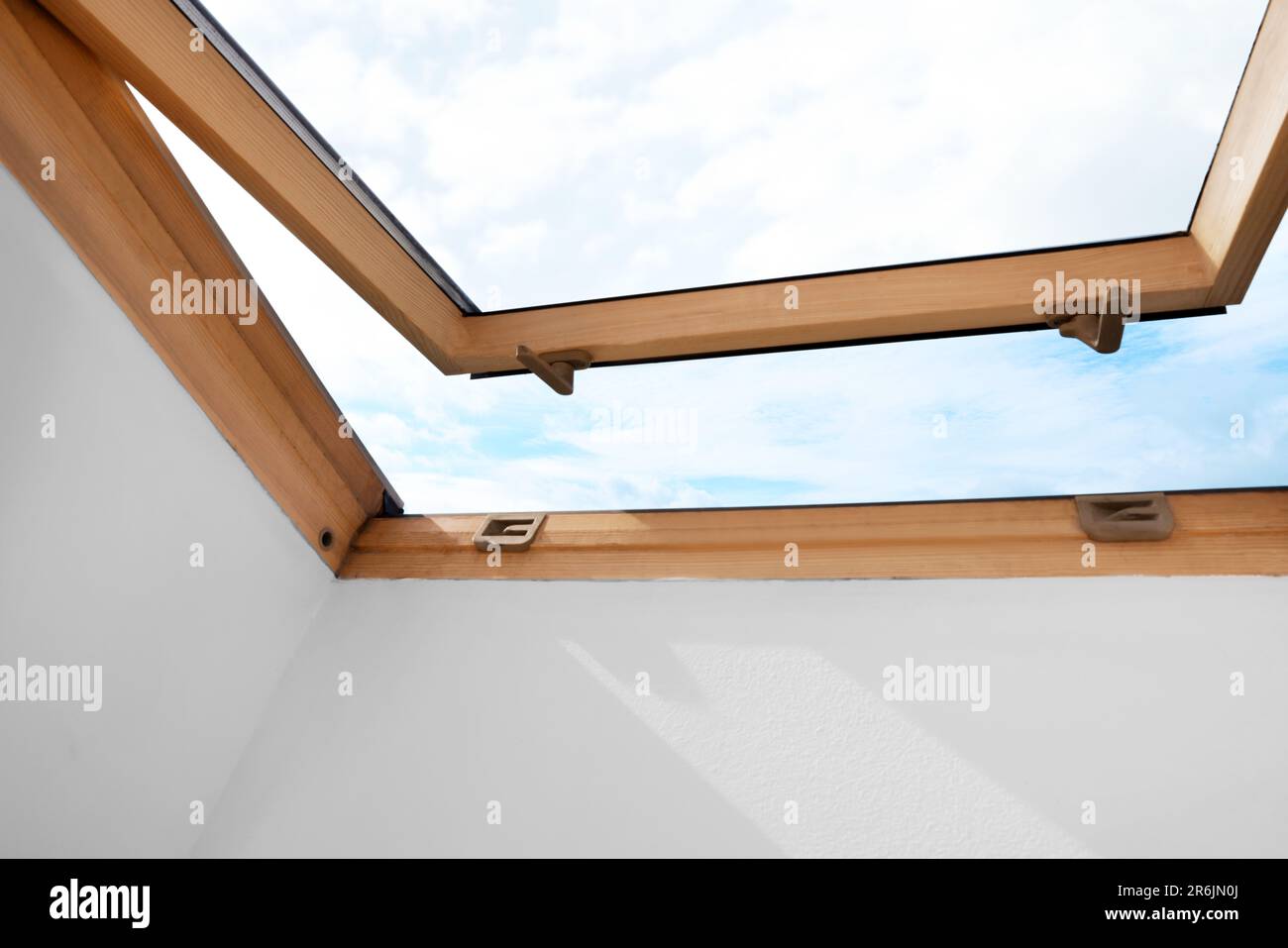 Beautiful view of cloudscape from open skylight roof window on slanted ceiling. Attic room Stock ...