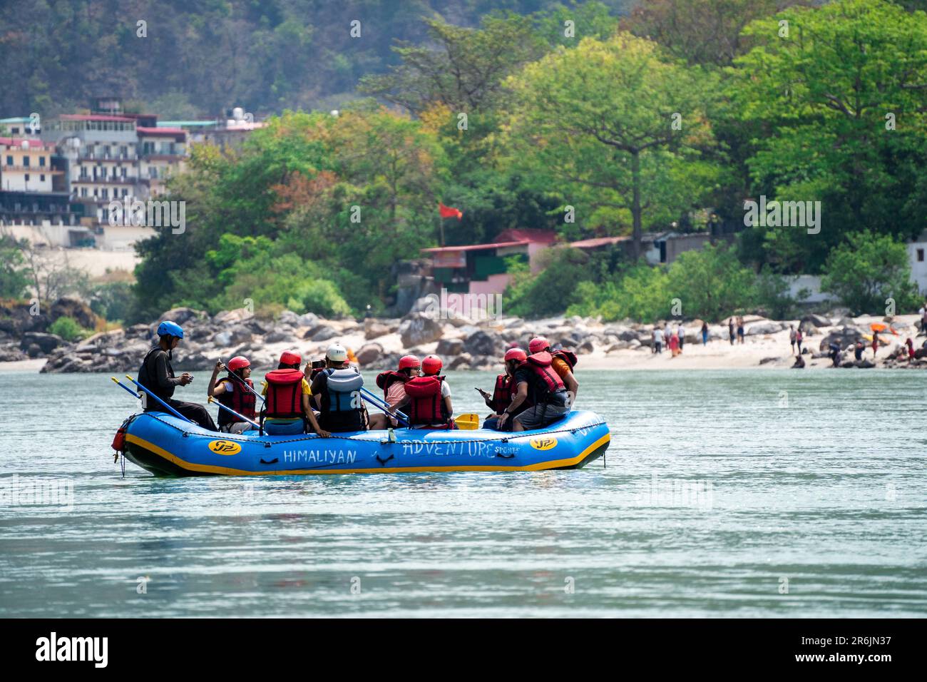 family friends sitting in raft enjoying adventure sports while crossing ...