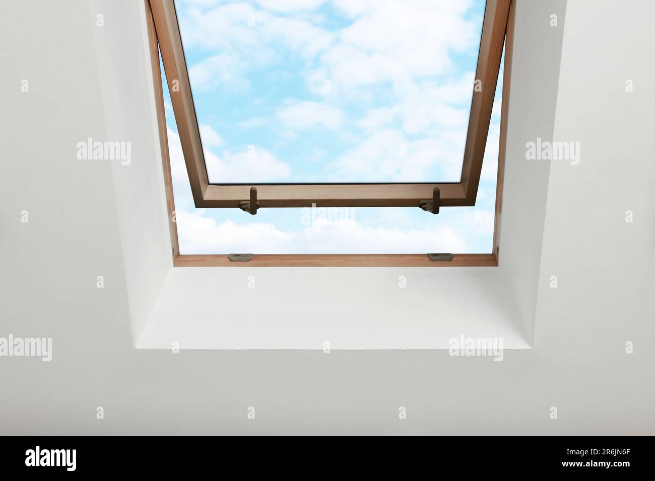 Open skylight roof window on slanted ceiling in attic room, bottom view Stock Photo - Alamy