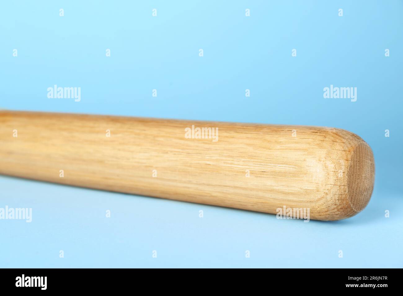 Wooden baseball bat on light blue background, closeup. Sports equipment ...