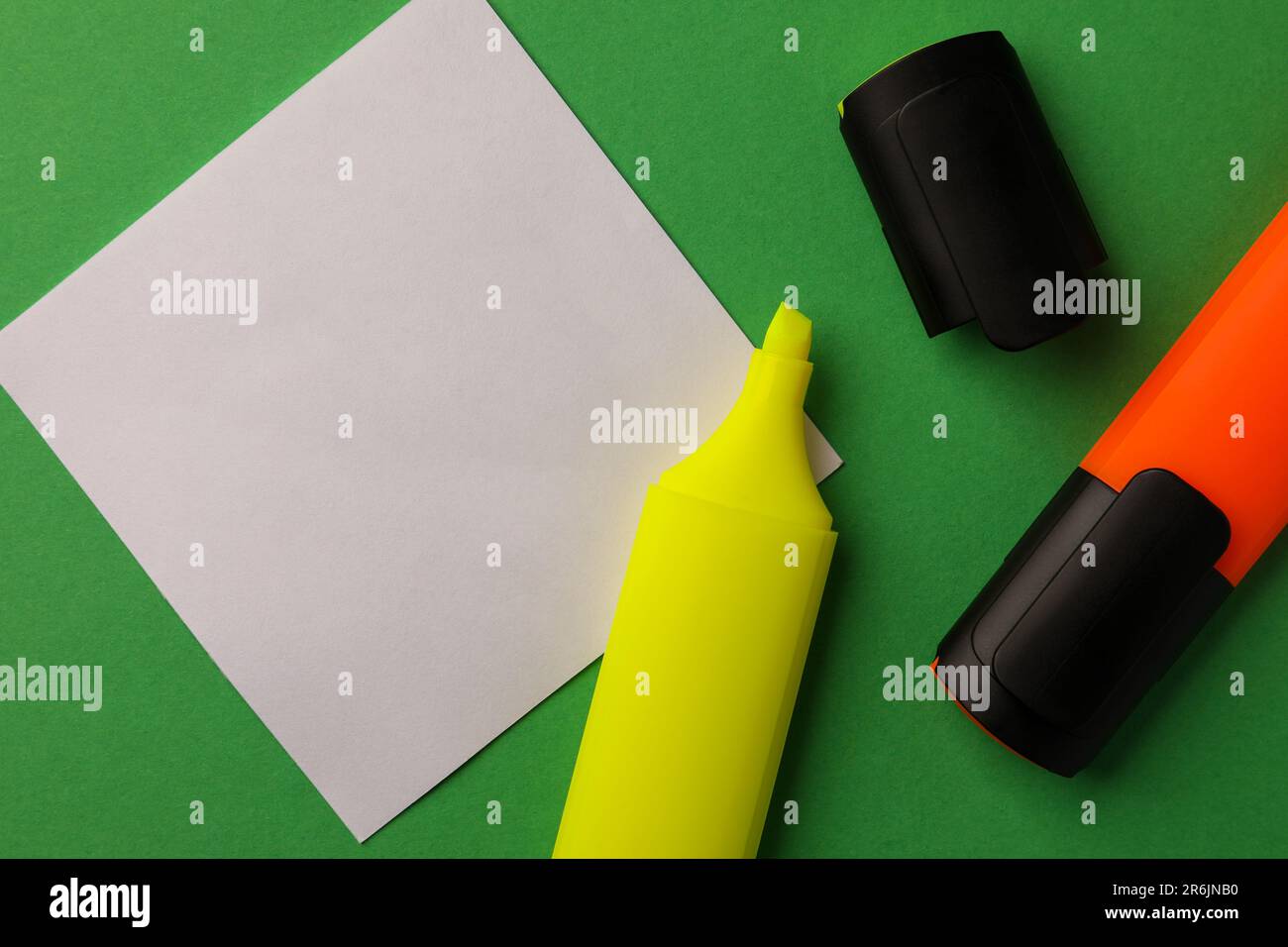 Bright color markers and sticky note with drawn arrow on green ...