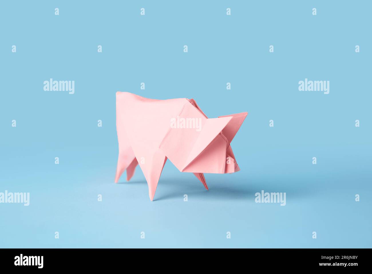 Origami art. Handmade pink paper pig on light blue background Stock ...