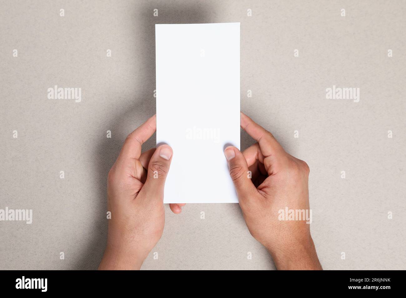 Man holding flyer on grey background, closeup. Mockup for design Stock ...