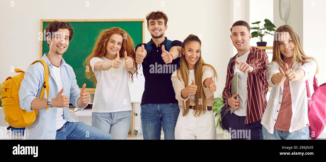 Group of cheerful positive students together showing thumbs up ...
