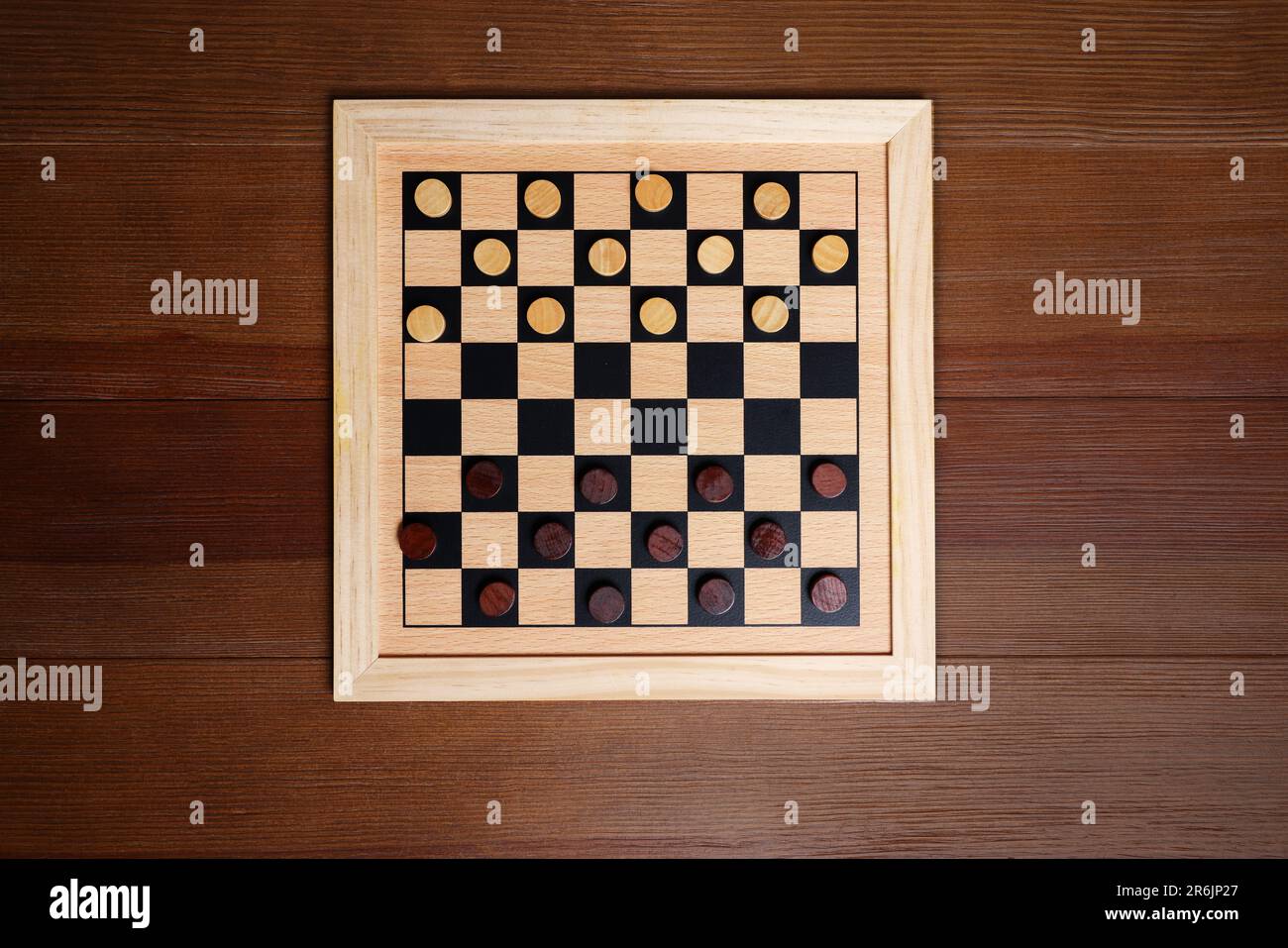 Checkerboard with game pieces on wooden table, top view Stock Photo - Alamy