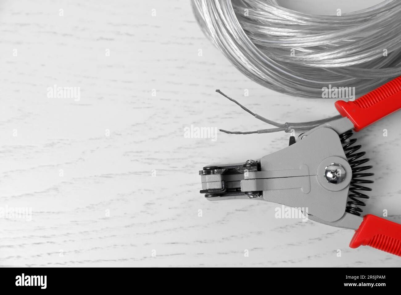 Professional cutters and cable with stripped wire on white wooden table ...