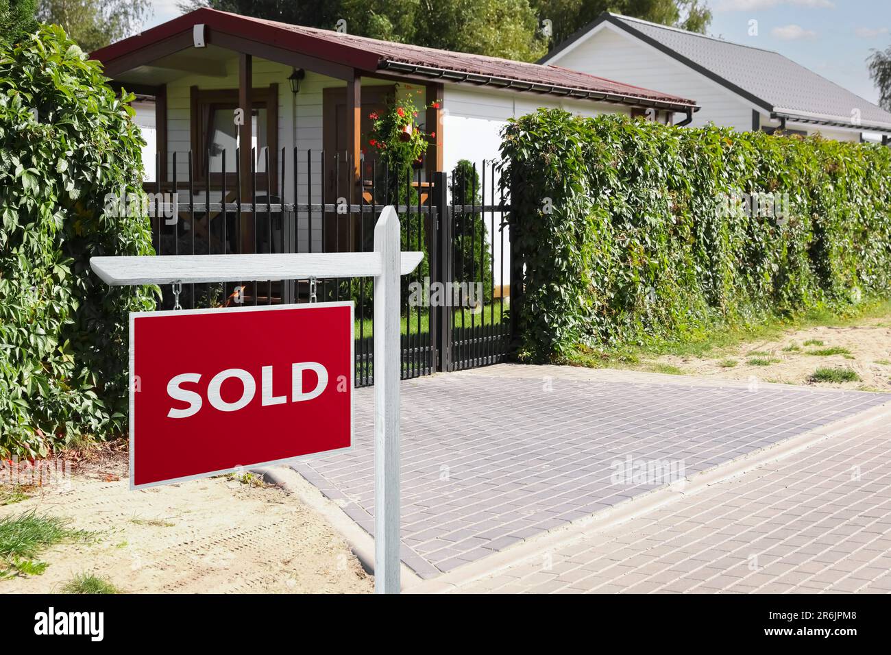 Red Sold sign near beautiful house outdoors Stock Photo - Alamy