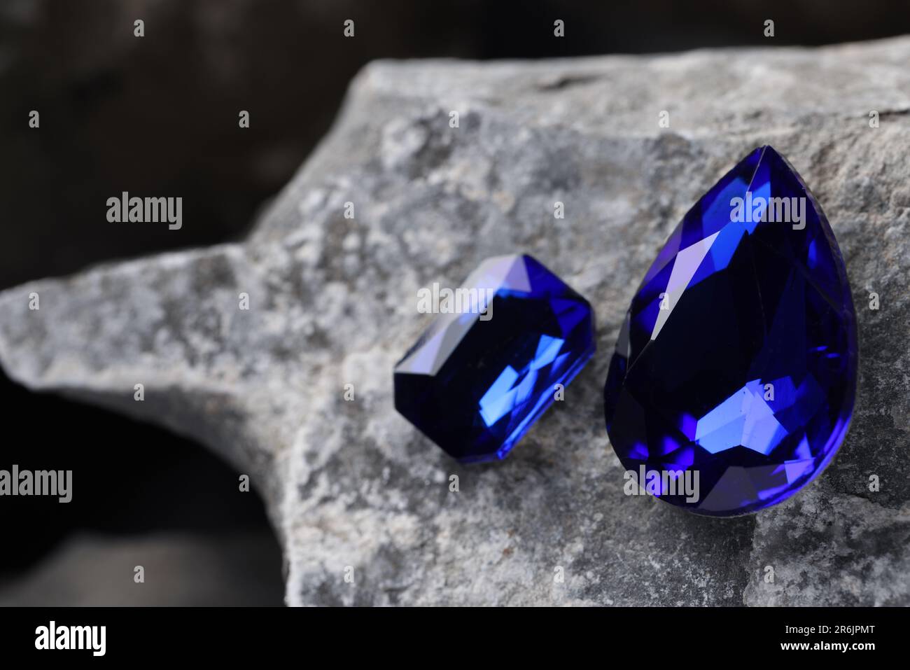 Two beautiful blue gemstones for jewelry on stone surface, closeup ...