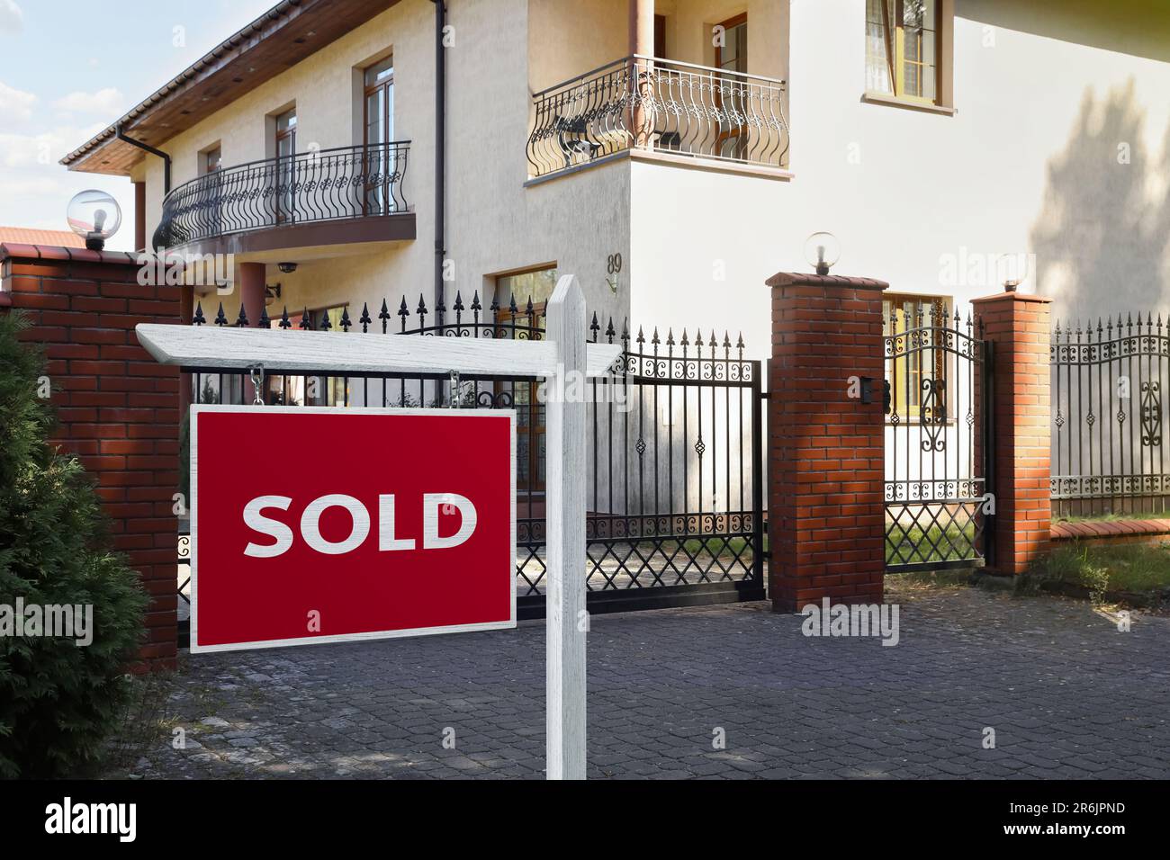 Red Sold sign near beautiful house outdoors Stock Photo - Alamy