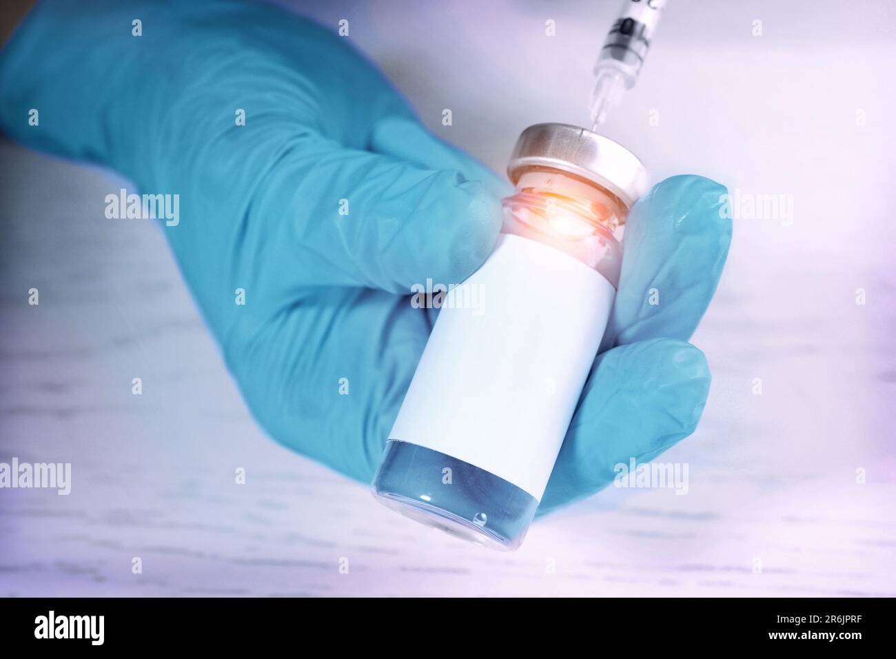 Laboratory worker filling syringe with medication from vial over white ...