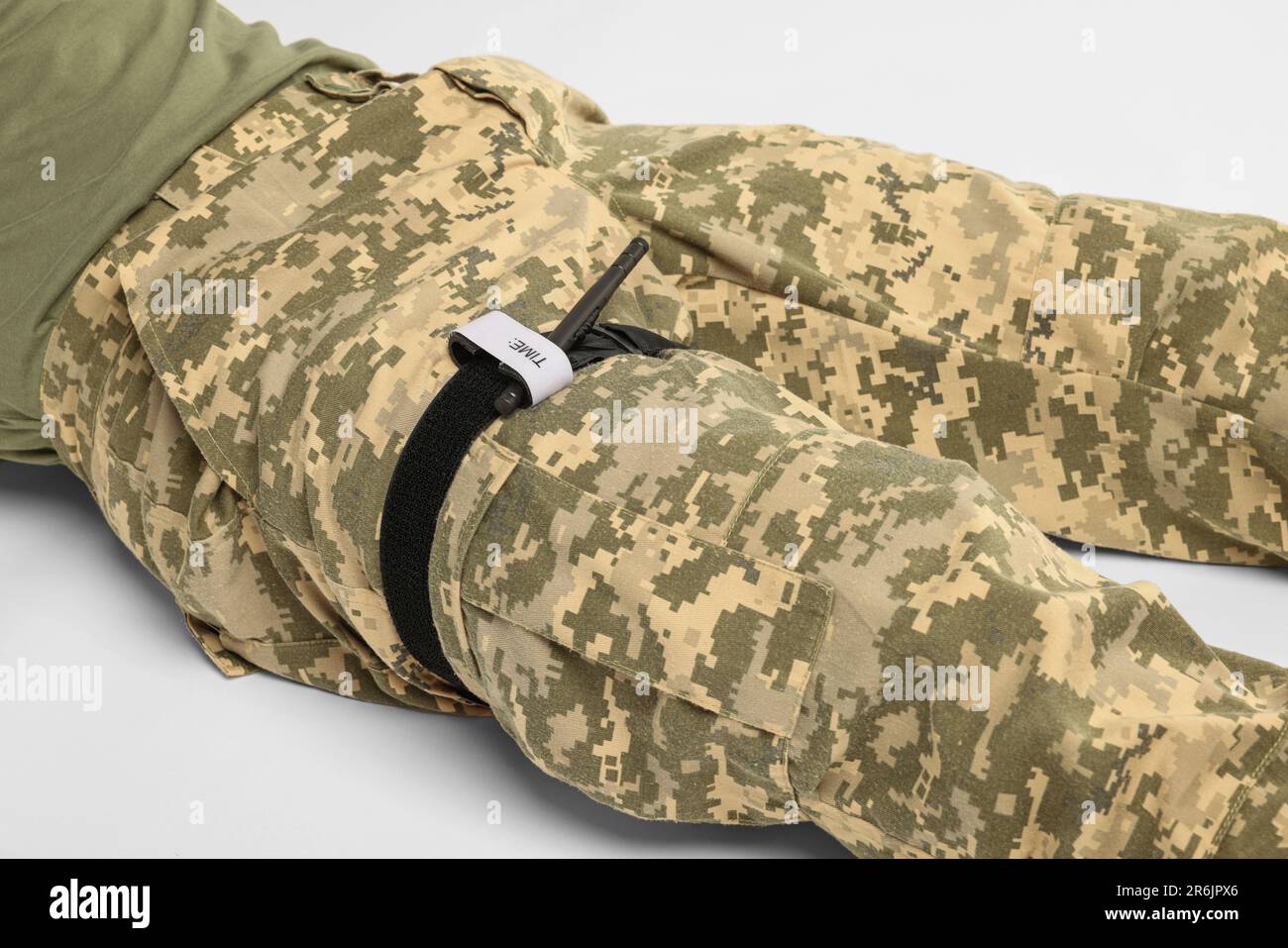 Soldier in military uniform with medical tourniquet on leg against ...