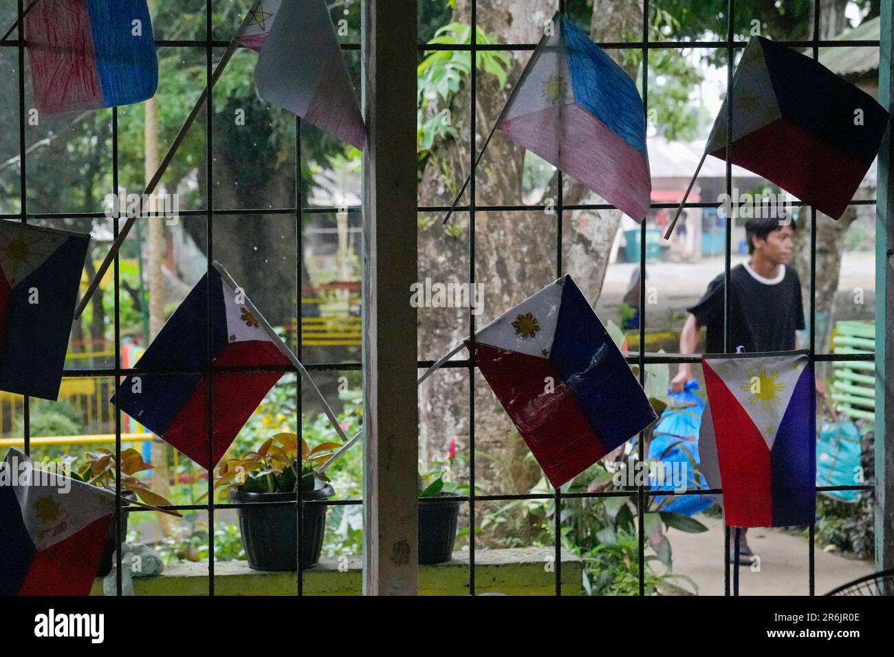 An evacuee carry belongings past small Philippine flags as they arrive ...