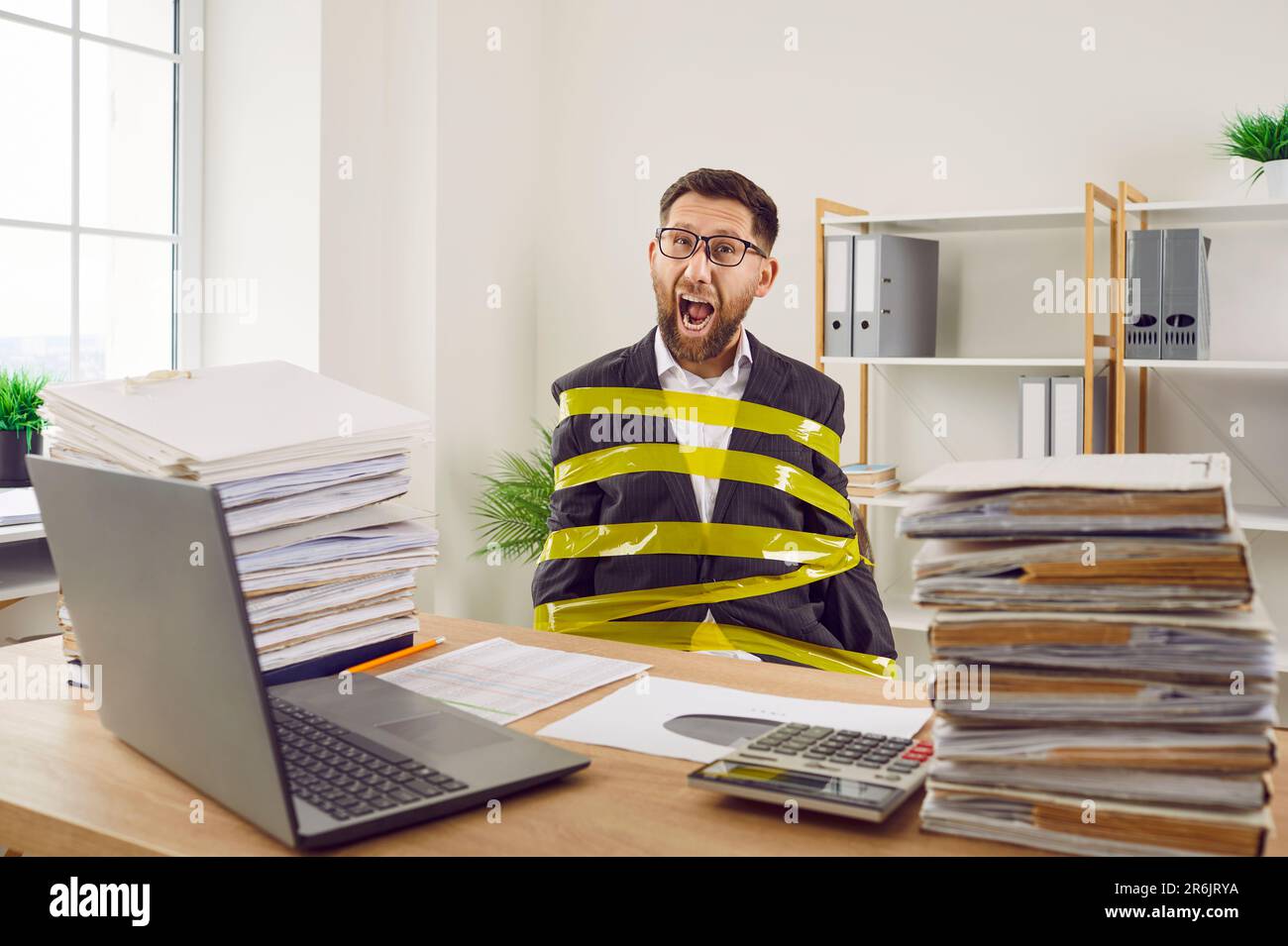 Funny office employee, stuck at work and wrapped with scotch tape ...