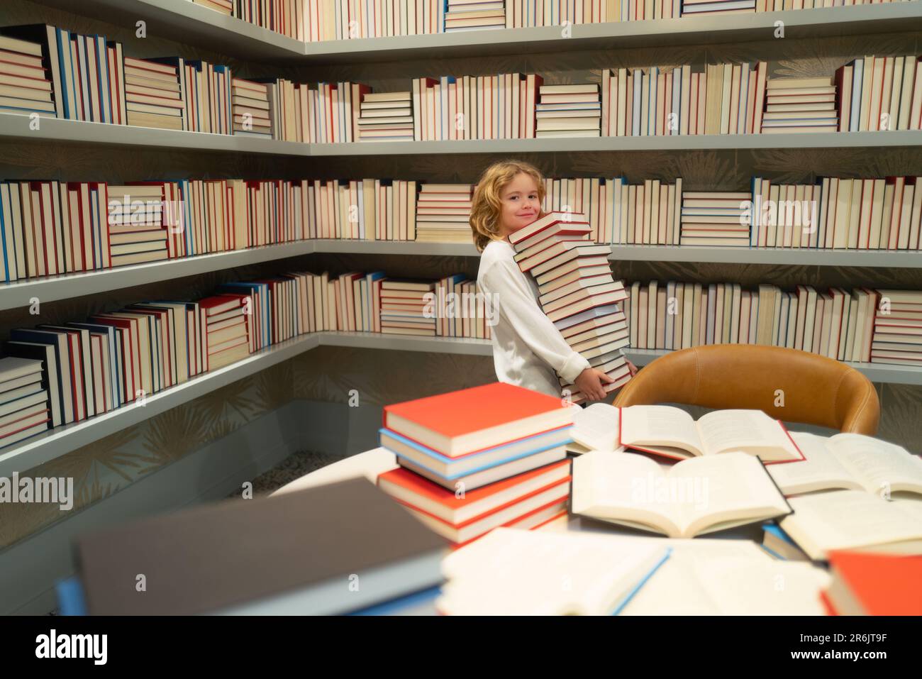 School child studying in school library. Kid reading book in library on ...
