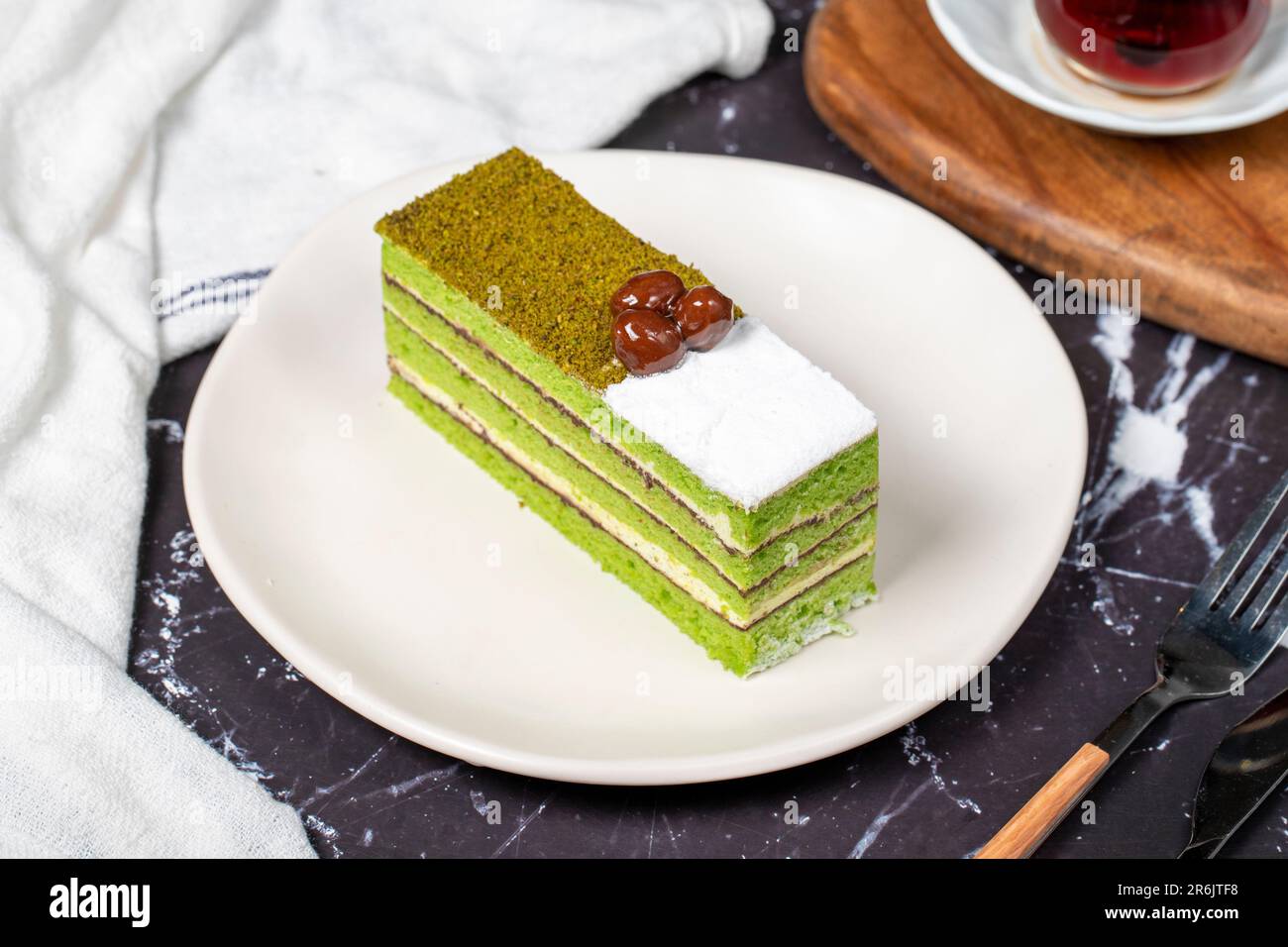 Mini slice colorful green pistachio cake. Delicious cream cake on dark ...