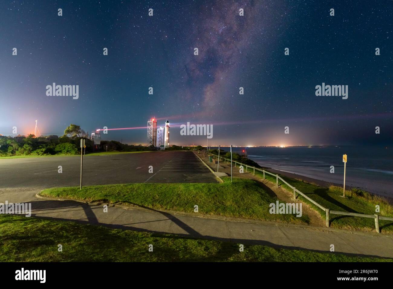 Night scene of an empty carpark and lookout near a lighthouse with ...