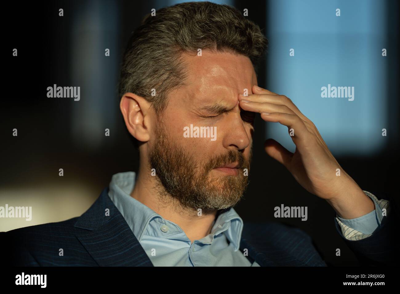 Tired exhausted man suffering from headache. Overworked burnout man ...