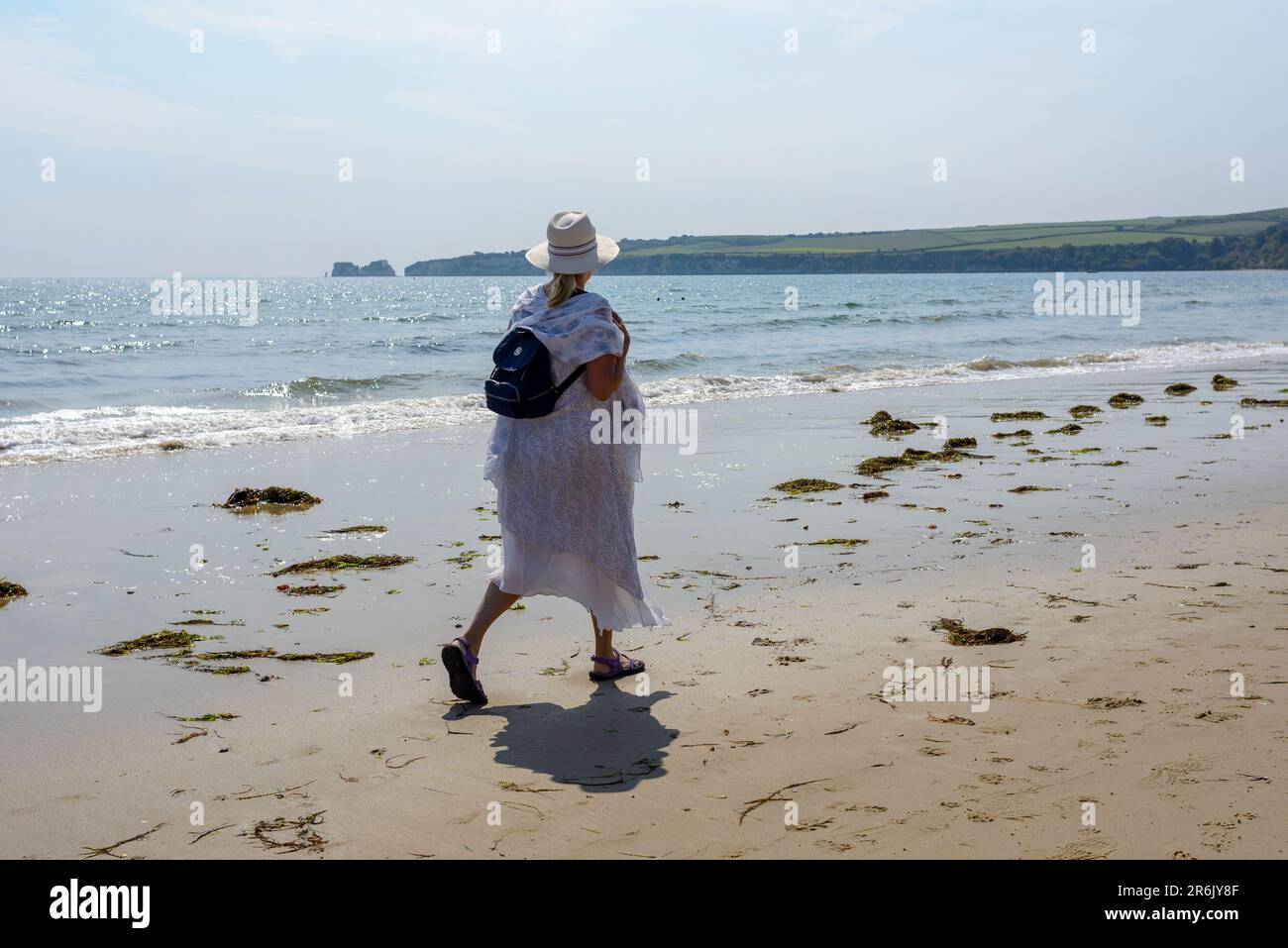 Woman walking on a beach in summer, Knoll Beach, Shell Bay, Studland ...