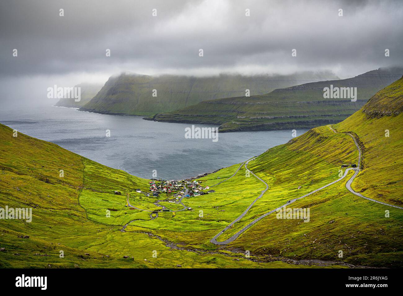 Storm clouds over the coastal village of Funningur along the fjord ...
