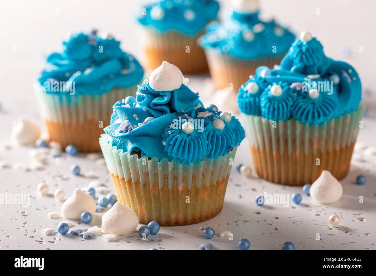Tasty and sweet cupcakes with blue whipped cream. Perfect blue dessert ...