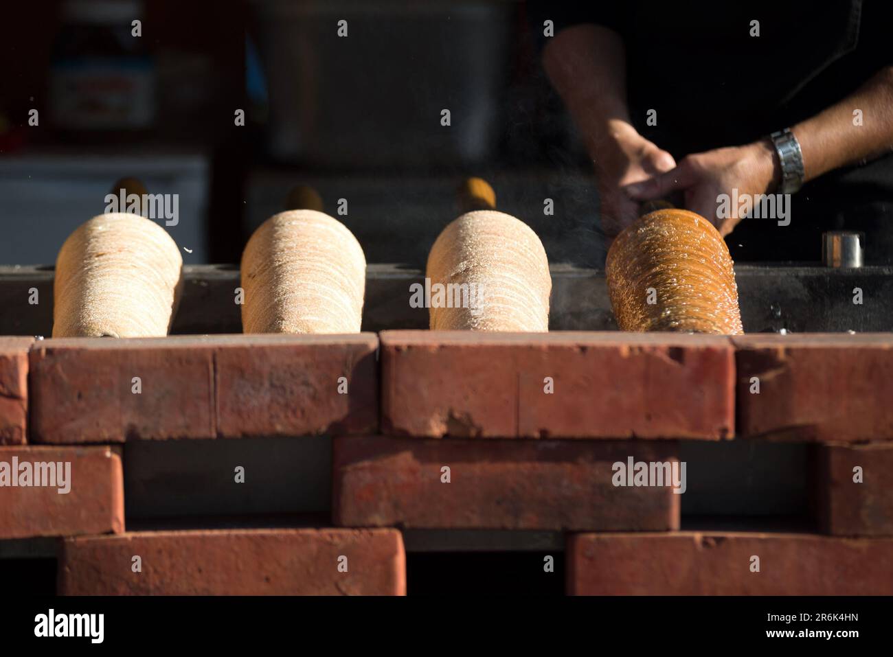 Baking a spit cake (Kürtőskalács Stock Photo - Alamy