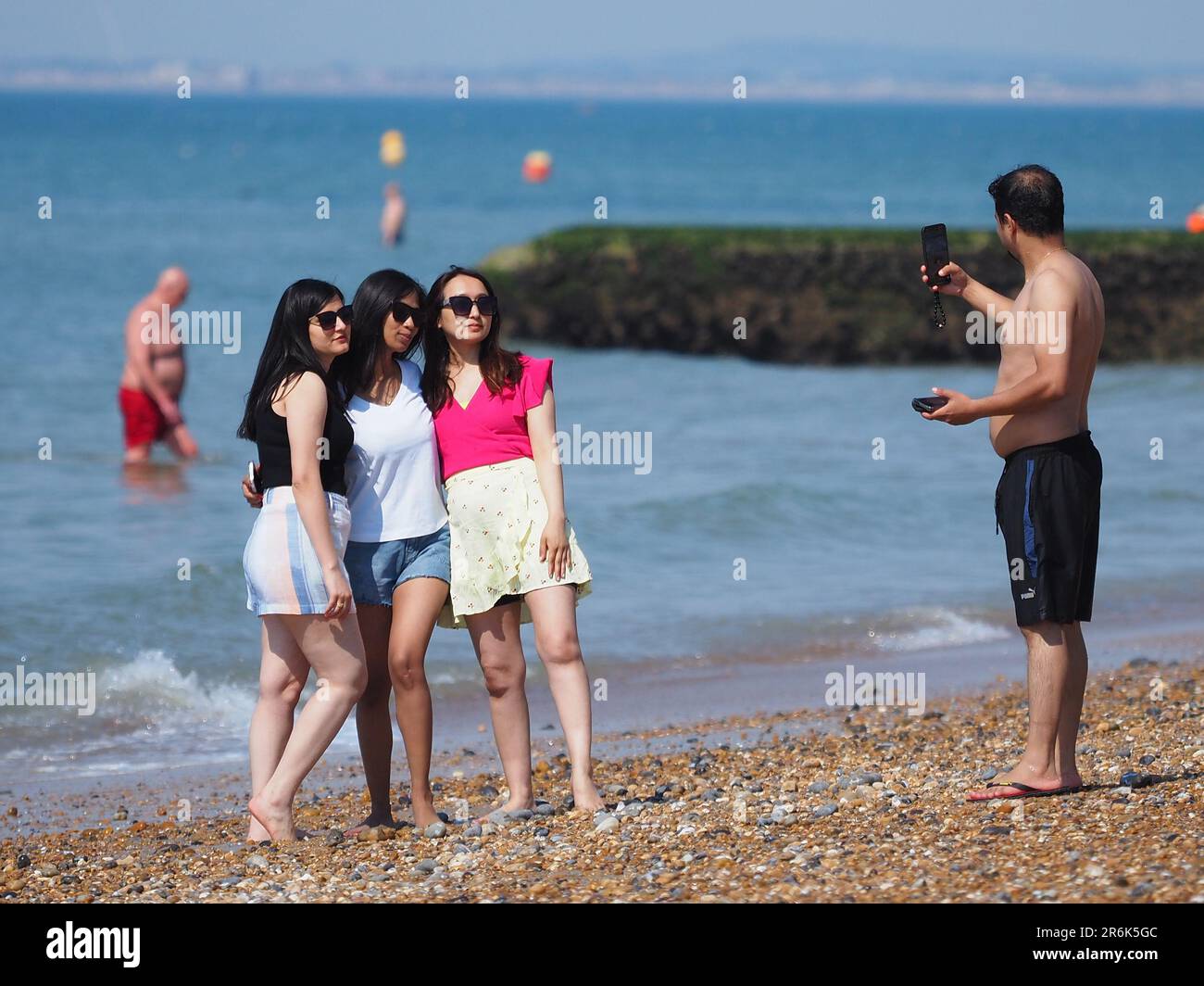 Beachgoers pose for a photo at Brighton beach in East Sussex as ...