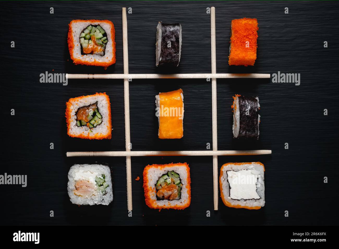 Various types of sushi and sushi sticks on a black wooden table Stock ...
