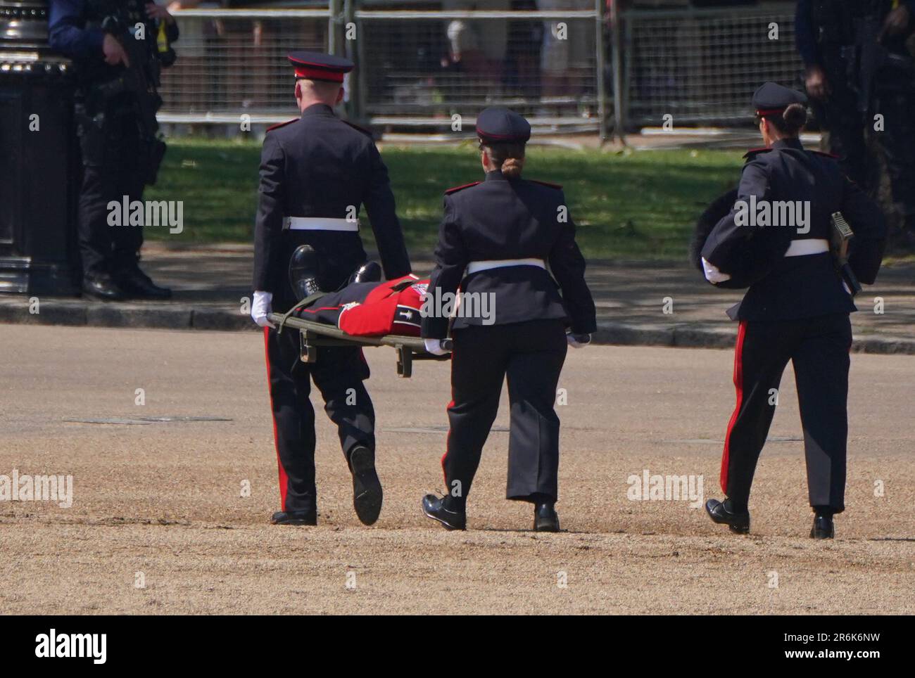 A member of the military is taken by stretcher from the parade ground ...