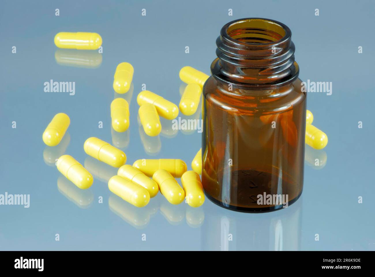Yellow pharmaceutical capsules in brown glass Stock Photo - Alamy